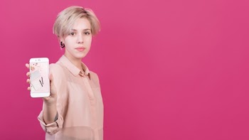 Free: Joyful Young Woman Jumping with Smartphone in Hand - nohat.cc